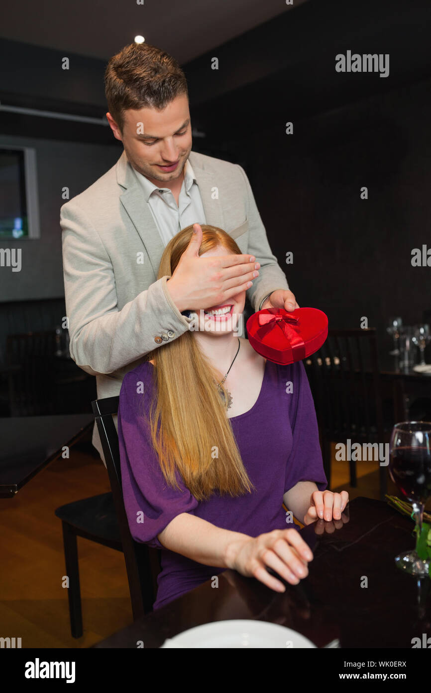 Handsome man offering present to his smiling girlfriend Stock Photo - Alamy