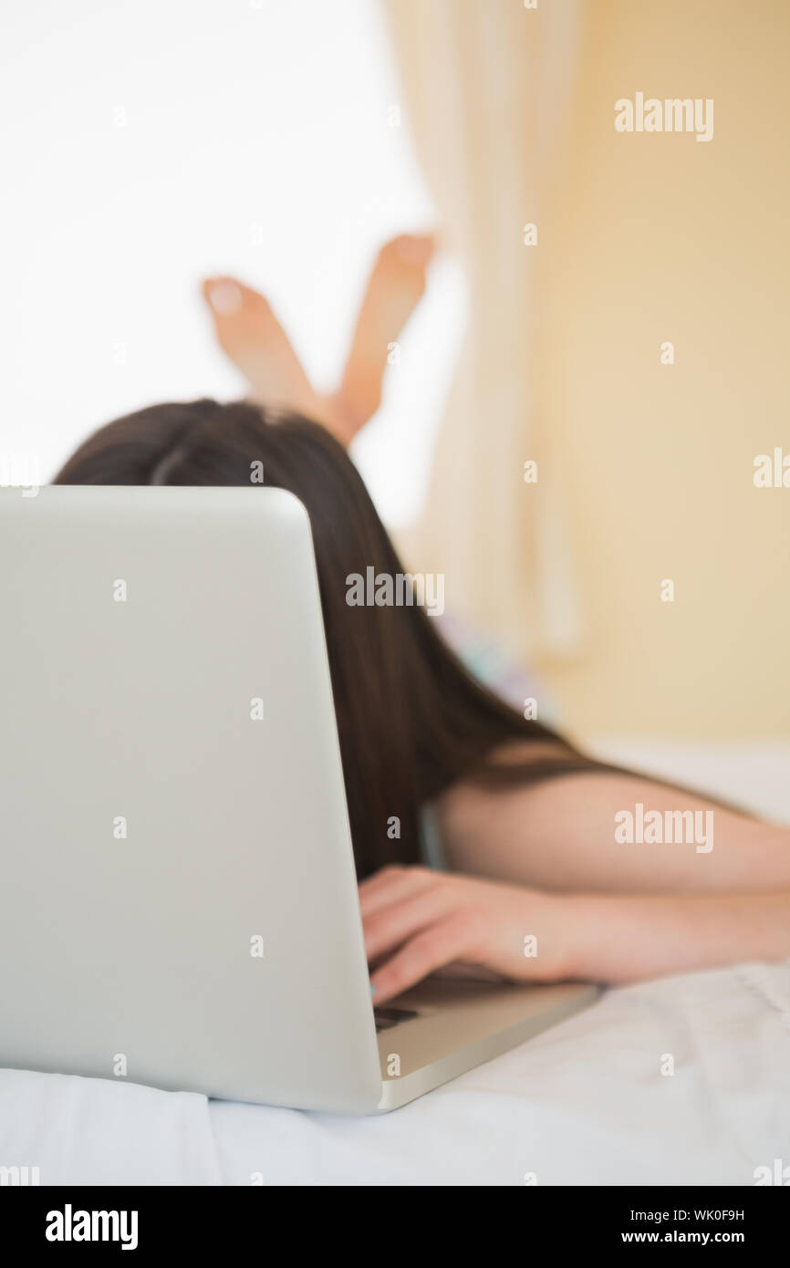 Laptop covering girls face on bed Stock Photo - Alamy