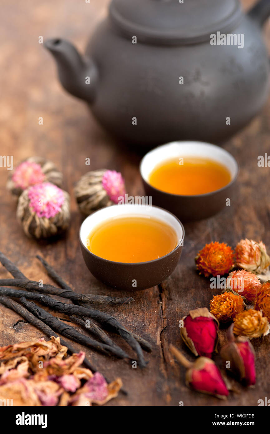 Chinese style herbal floral tea over wood table with raw ingredients ...