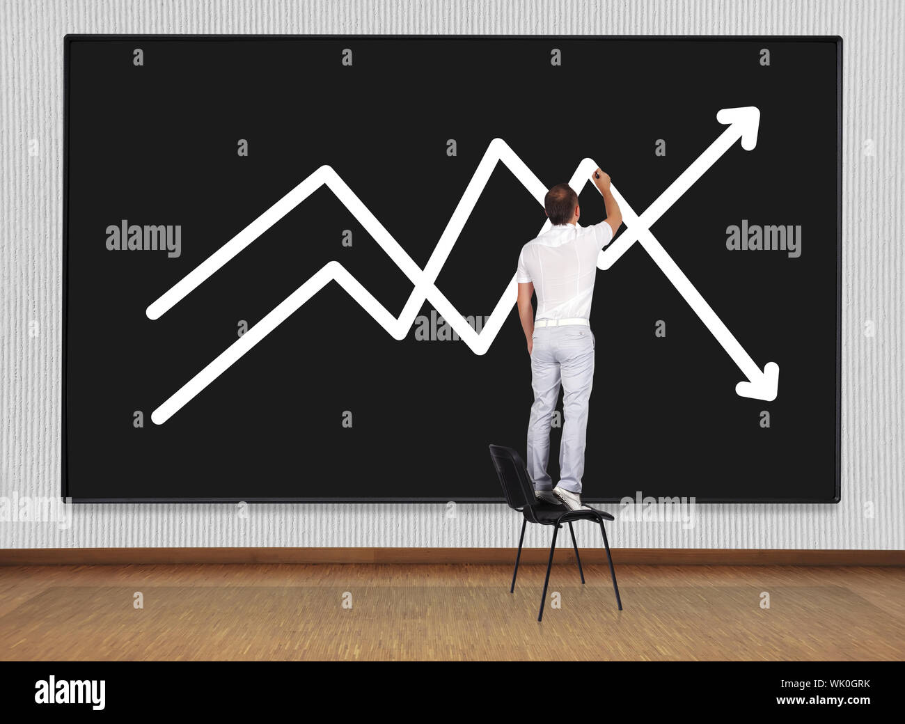 man standing on chair and drawing graph Stock Photo - Alamy