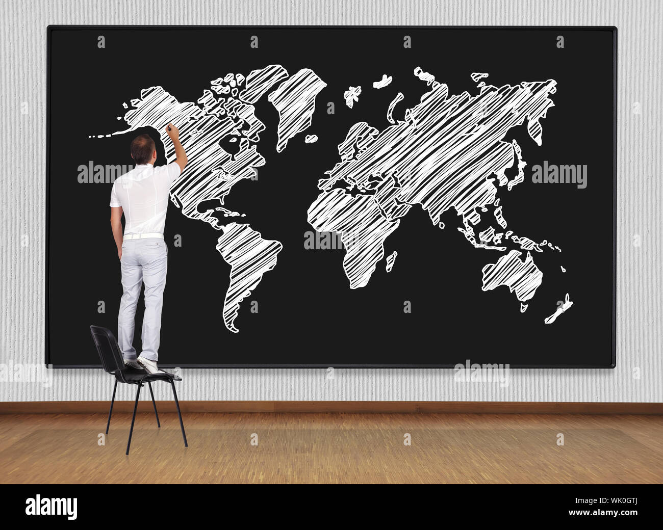 man standing on chair and drawing world map Stock Photo - Alamy