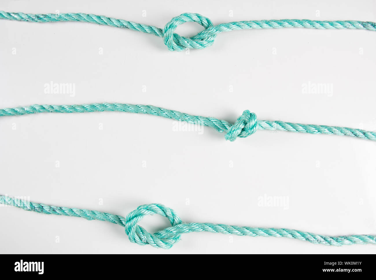 Knot tied on the green ropes isolated on white Stock Photo - Alamy