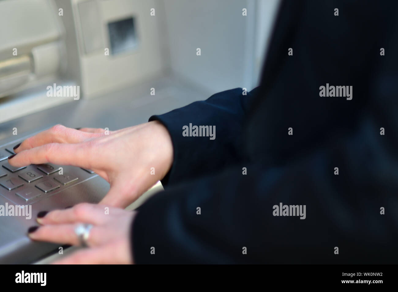 Woman entering code into atm machine Stock Photo - Alamy