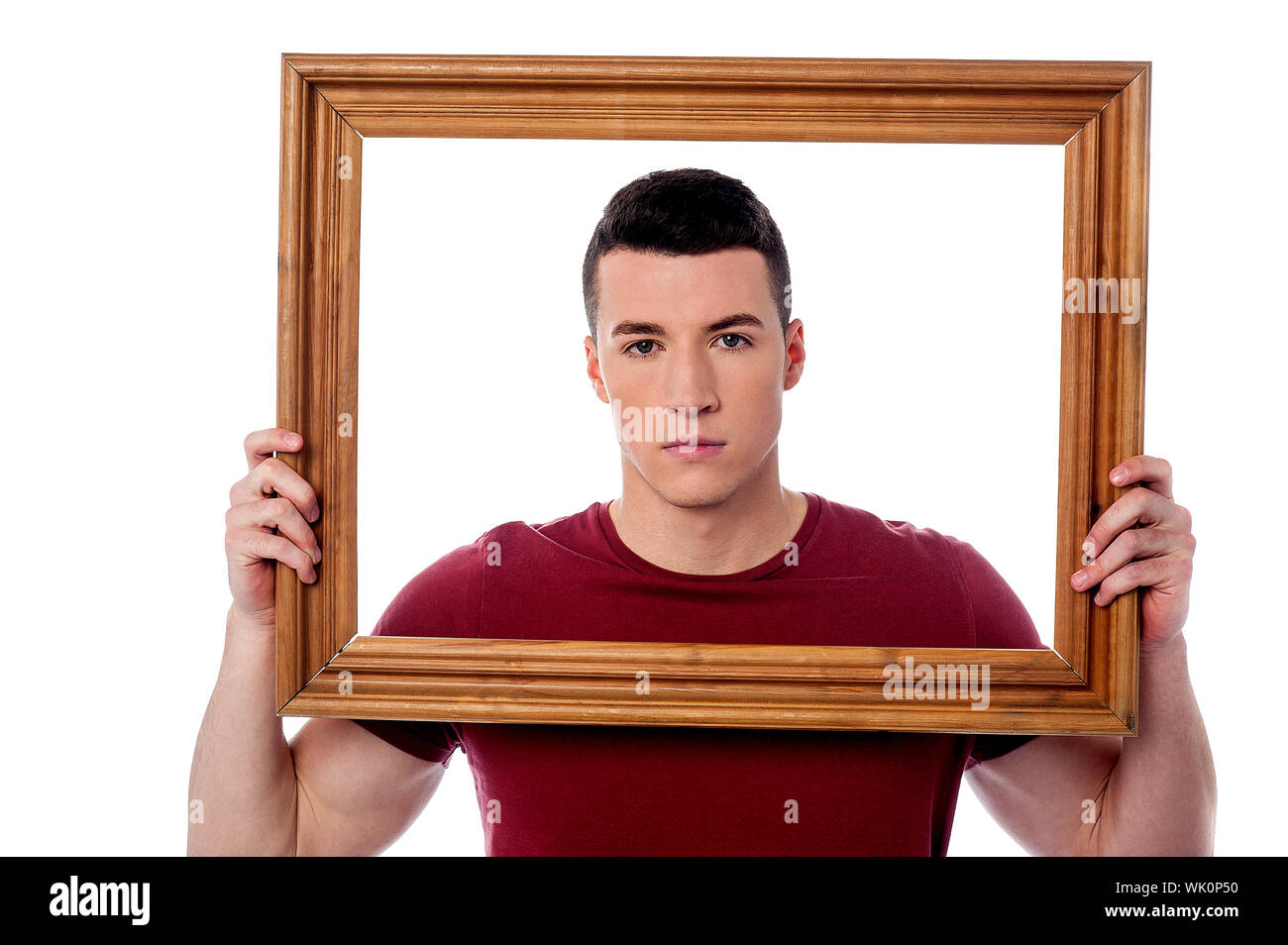 Happy guy looking through empty picture frame Stock Photo - Alamy