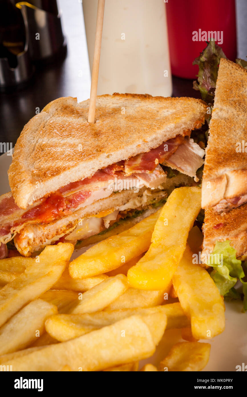 Club sandwich on toasted white bread with a meat filling served with ...