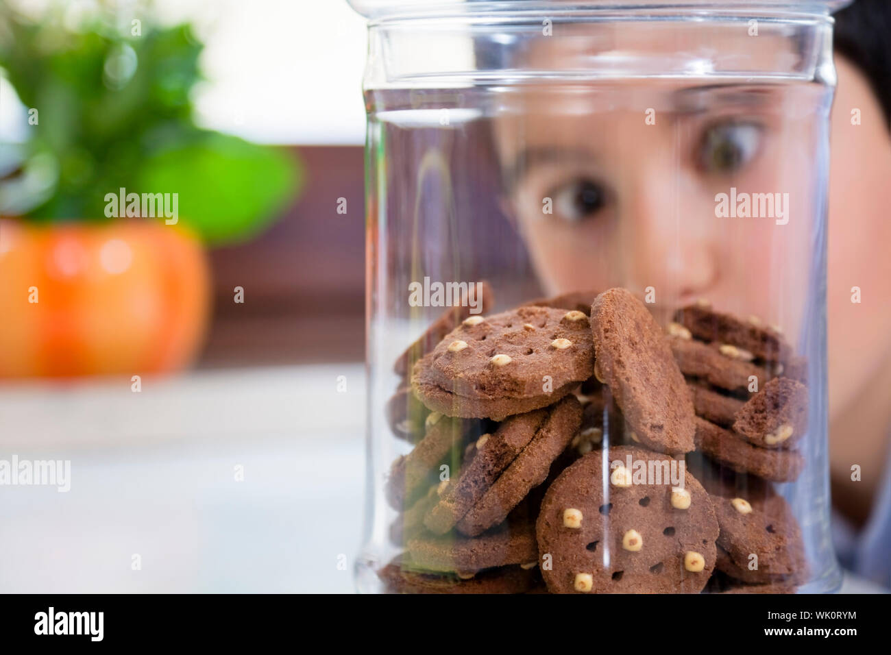 little boy looking at cookies in a jar Stock Photo - Alamy