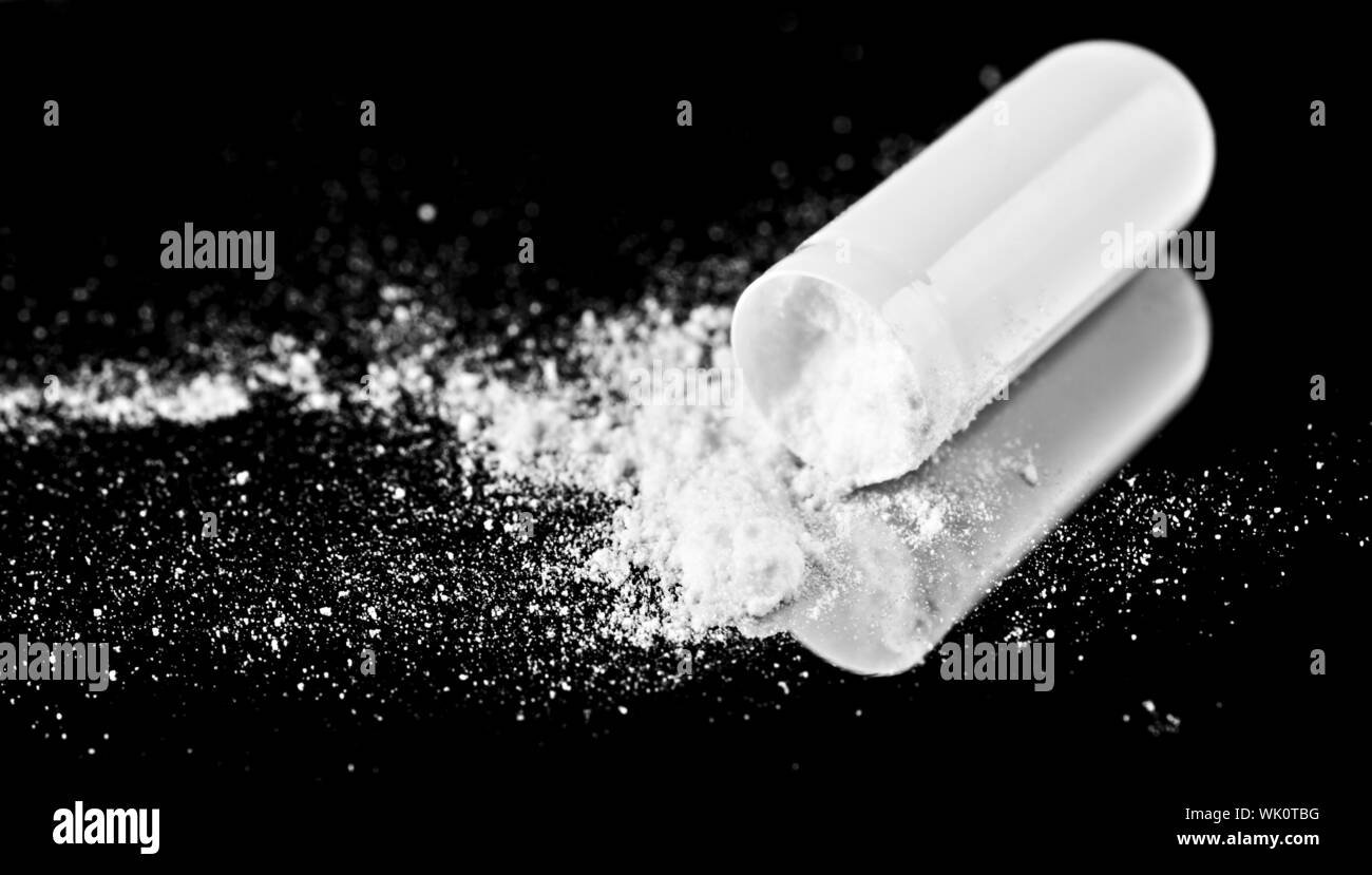 On a black glass dropped into the capsule contents Stock Photo - Alamy