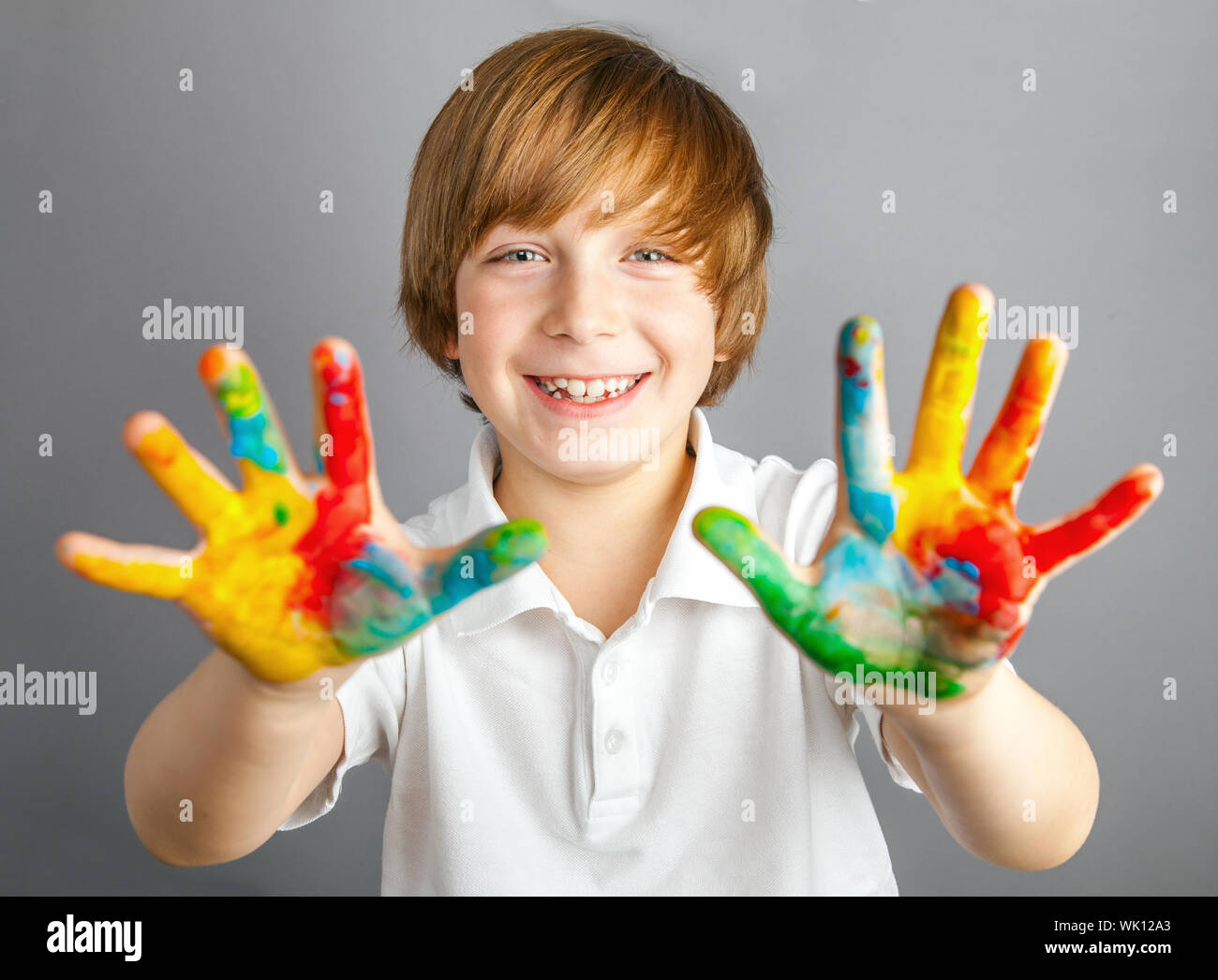 Smiling child showing his colored hands Stock Photo - Alamy