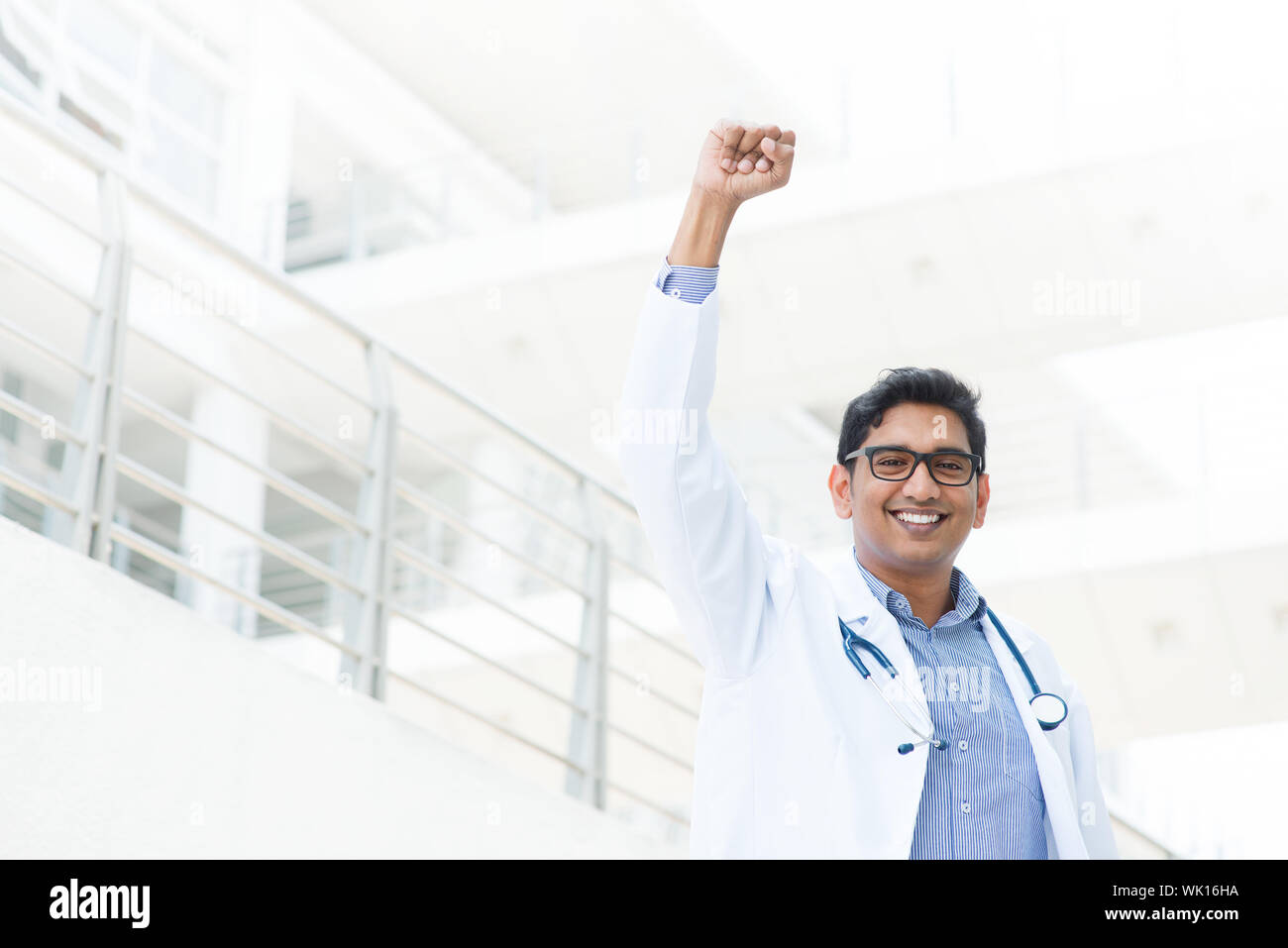 Successful Asian Indian medical doctor with arm up celebrating his ...