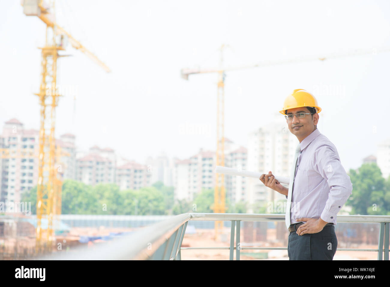 Portrait of a smiling Asian Indian male contractor engineer with hard ...