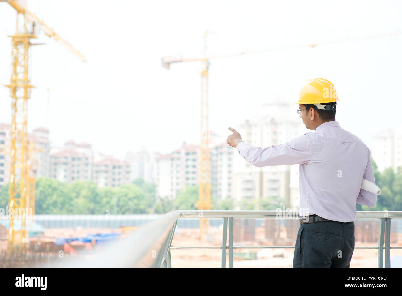 Portrait of a smiling Asian Indian male contractor engineer with hard ...