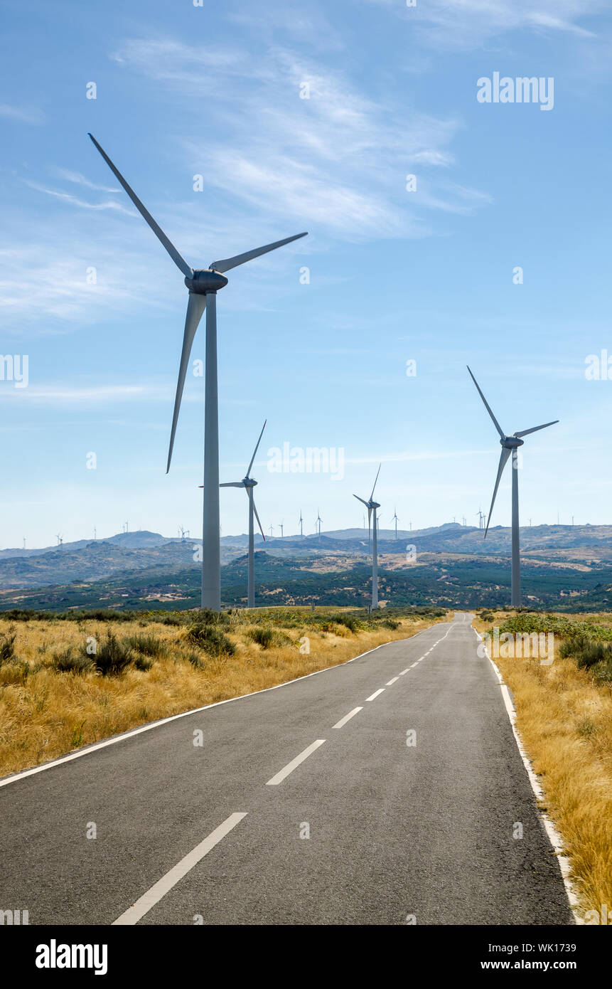 Asphalt road through a wind turbines mountain field Stock Photo - Alamy