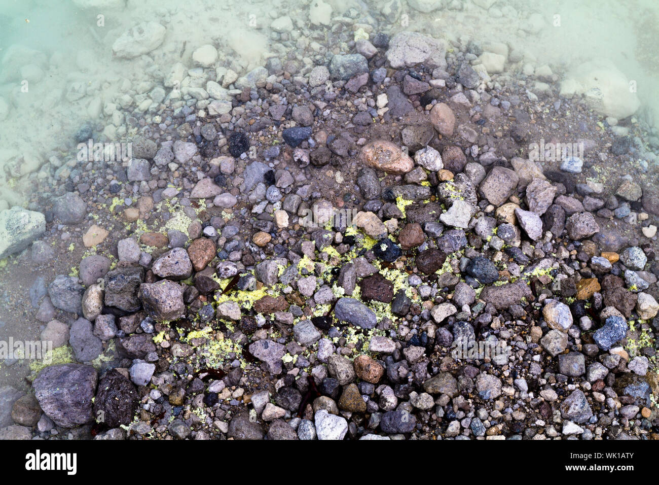 Sulphur accumulated between the rocks at the edge of volcanic crater ...