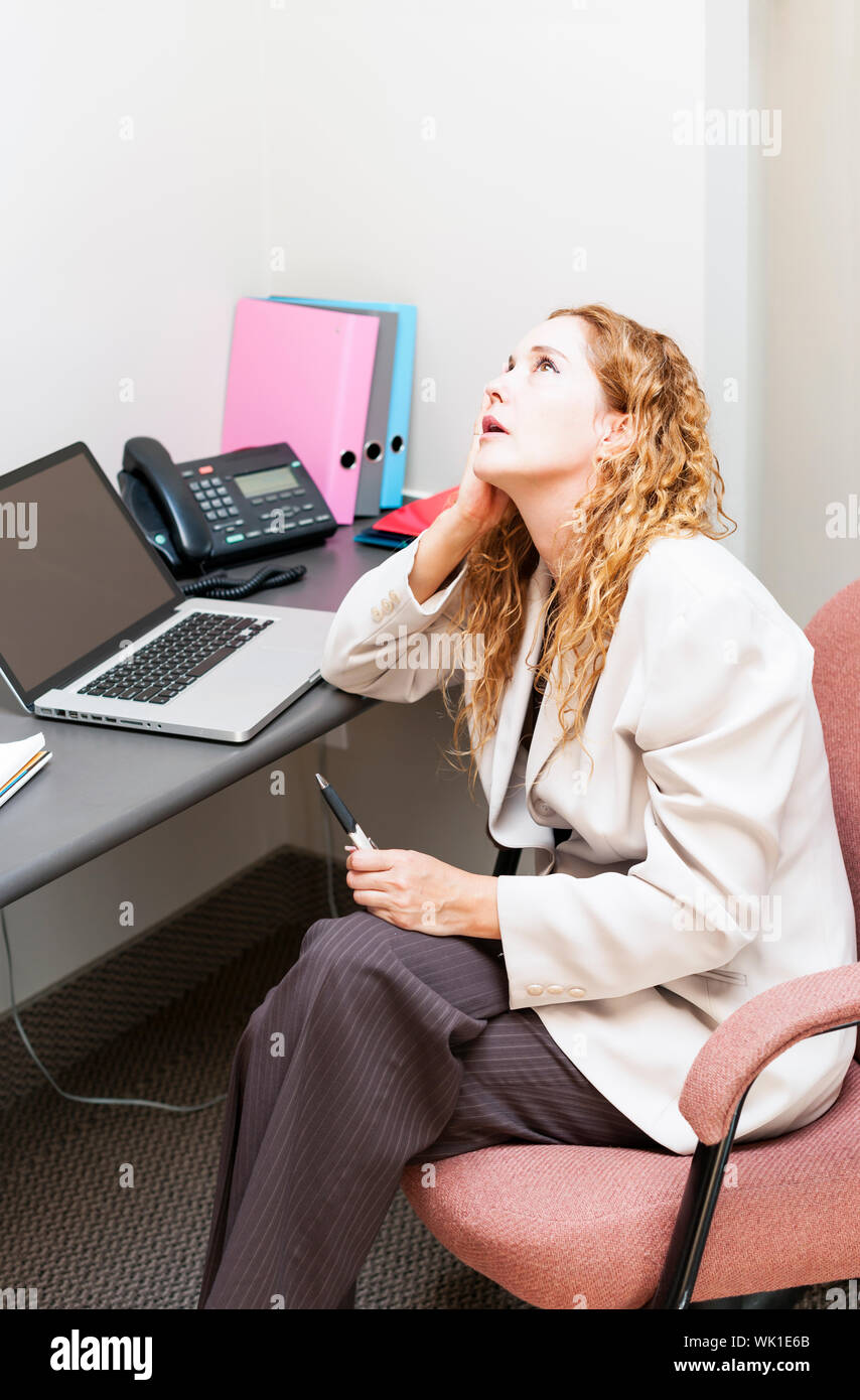 Businesswoman worried in office workstation looking up Stock Photo - Alamy