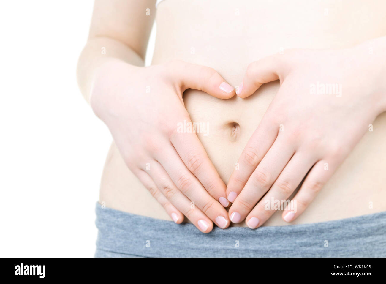 Woman showing heart shape with her hands on stomach Stock Photo - Alamy