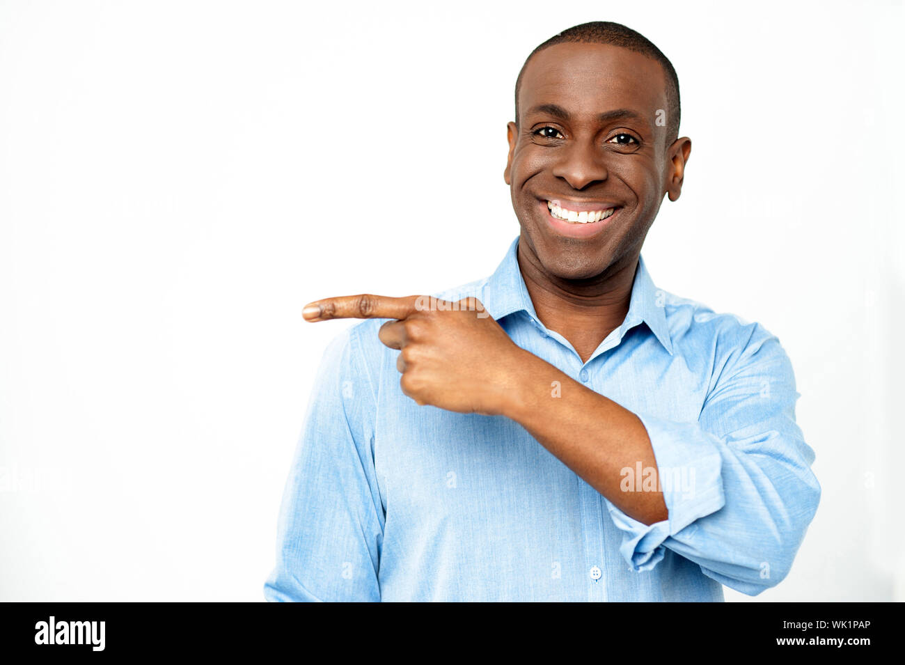 Guy pointing away while facing camera Stock Photo - Alamy