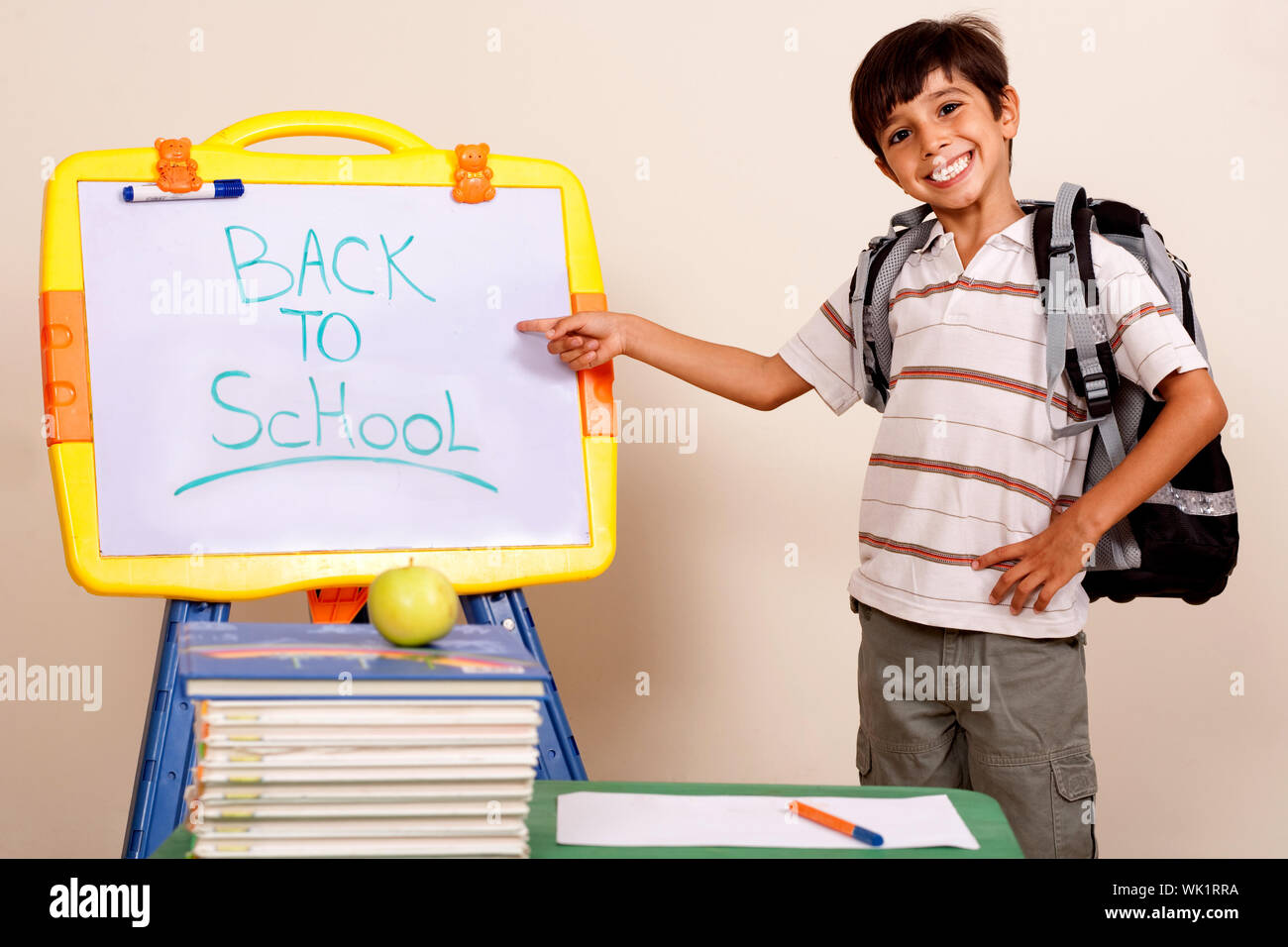 Smiling school boy pointing at white board on his classroom Stock Photo ...