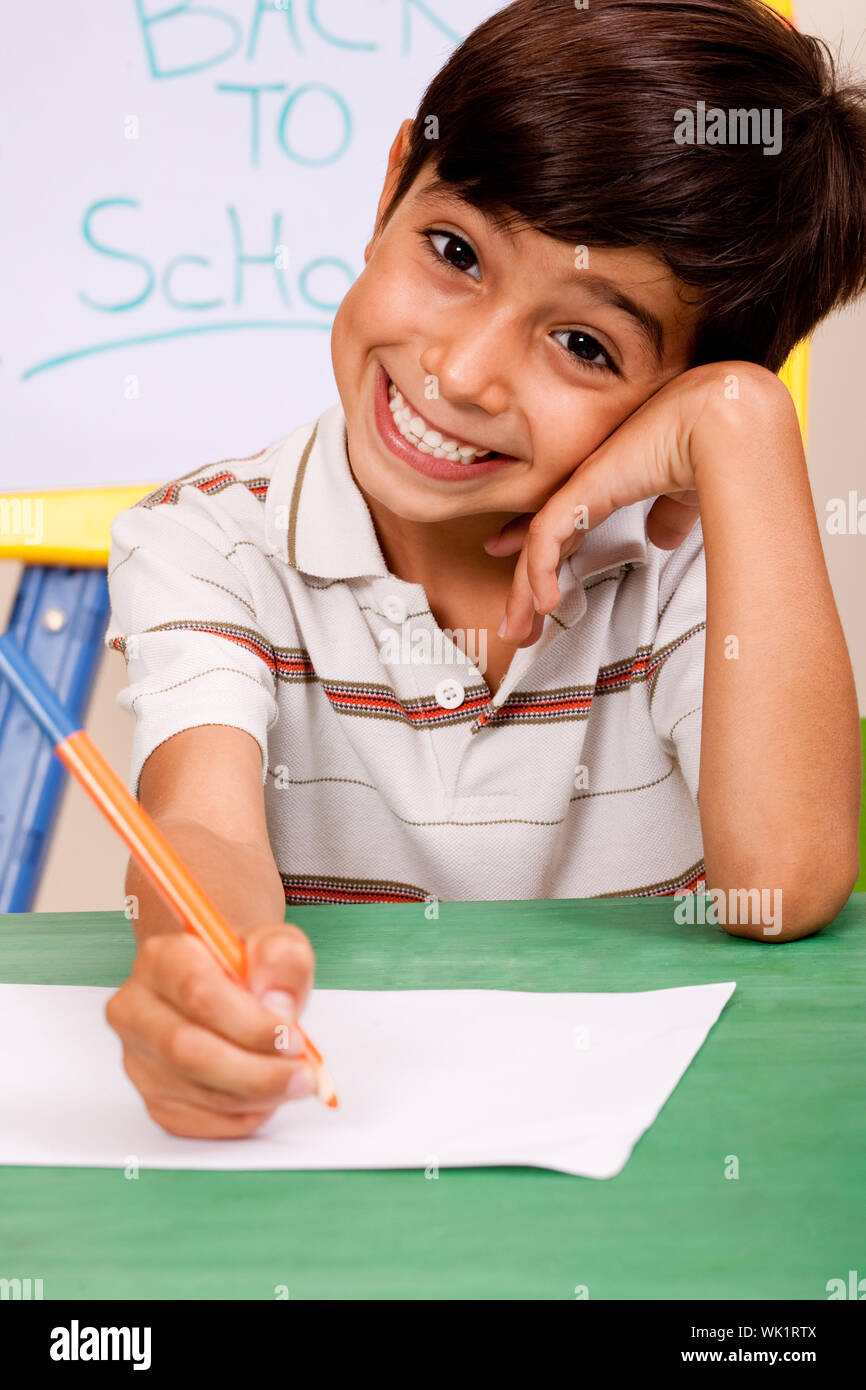 Closeup portrait of a cheerful young boy writing notes Stock Photo - Alamy