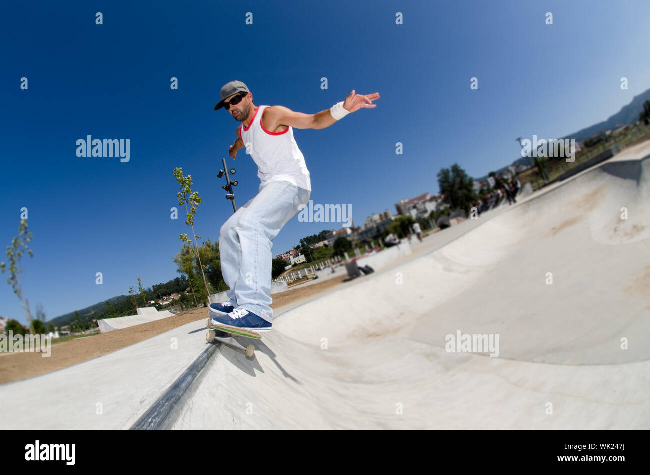 Skateboarder in a concrete pool at skatepark on a sunny day Stock Photo ...