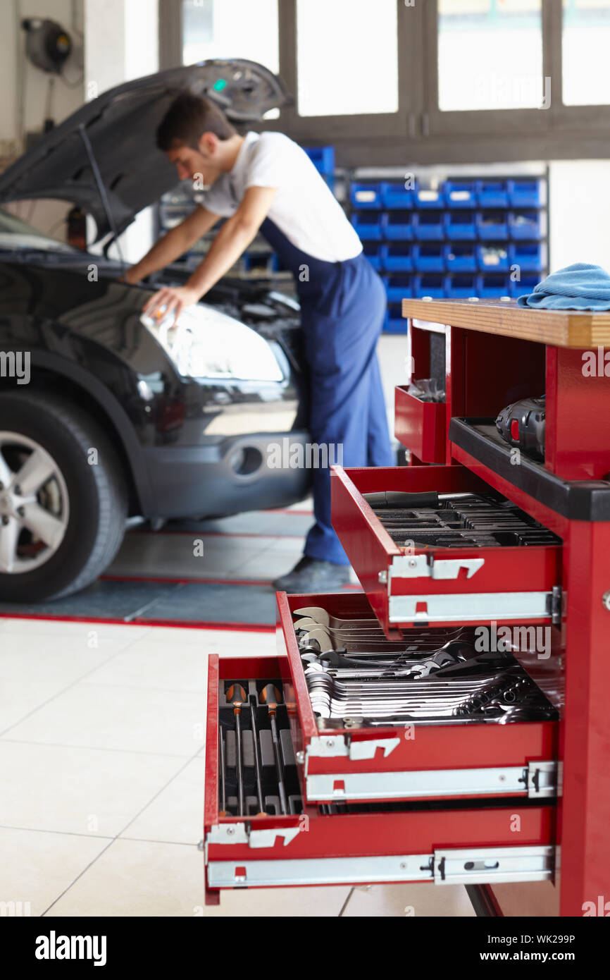 mechanic working on car engine. Focus on foreground Stock Photo - Alamy