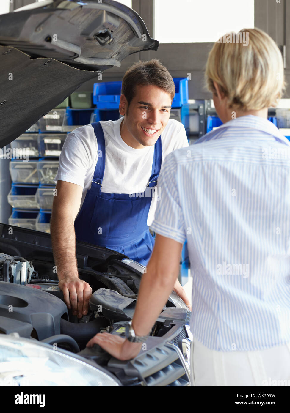 mechanic talking with female client in auto repair shop Stock Photo - Alamy