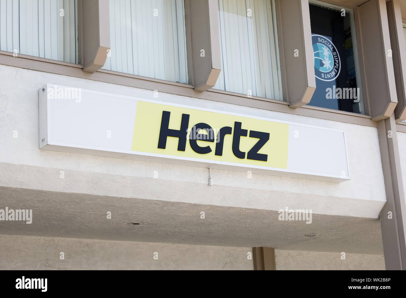 A store front sign for the car rental company known as Hertz Stock ...