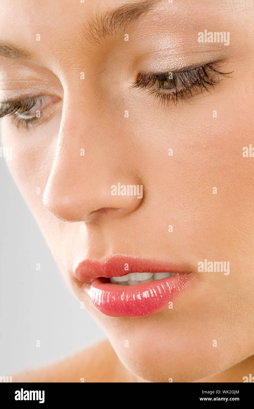 close up of a young and beautiful woman looking down with her eyes ...