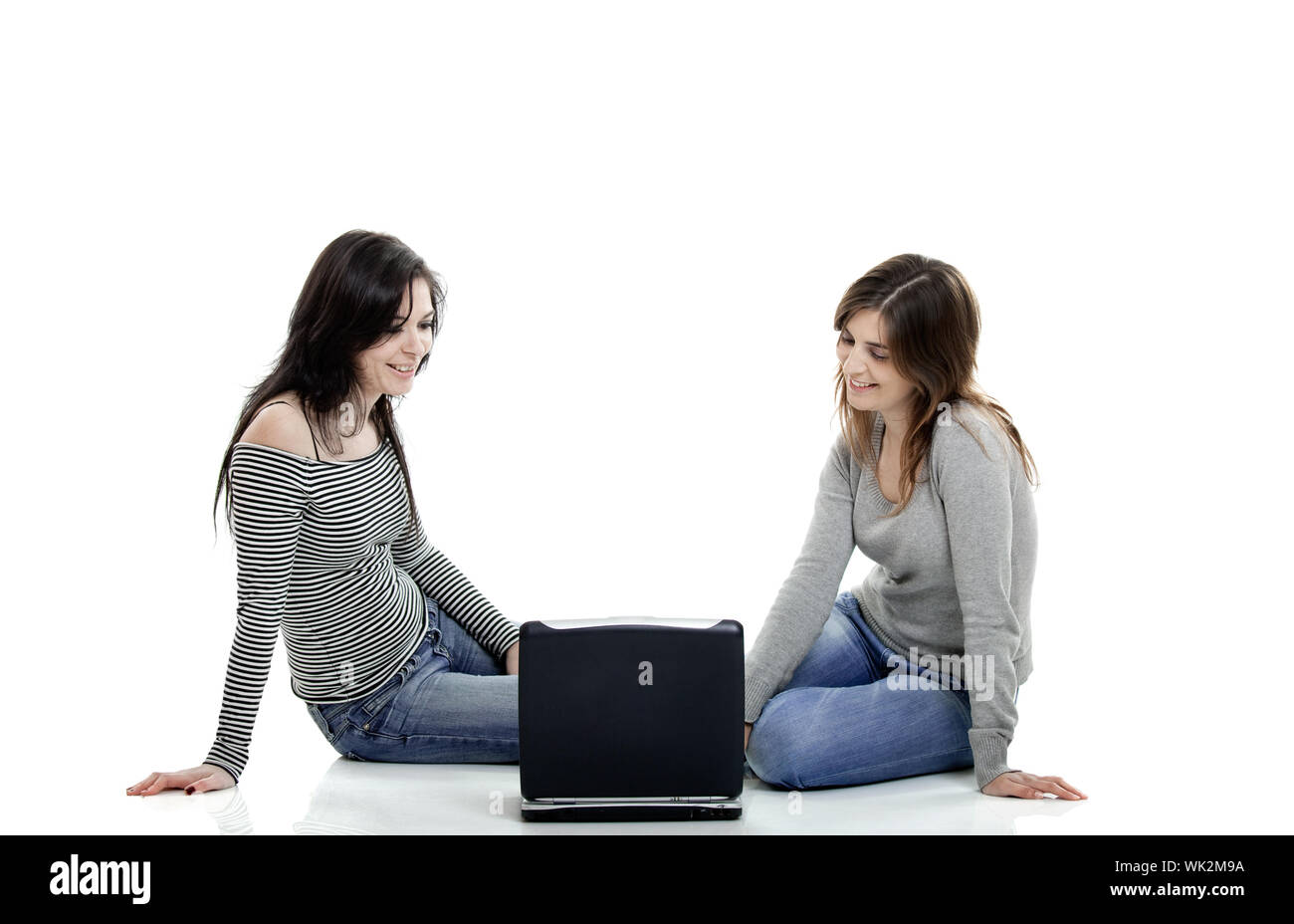 Two female young students working with a laptop Stock Photo - Alamy