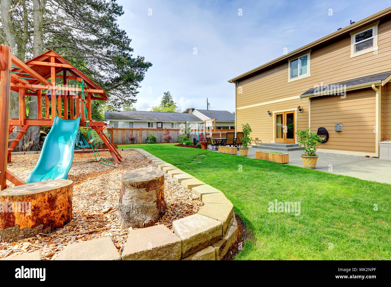 Backyard with patio area and playground for kids Stock Photo - Alamy