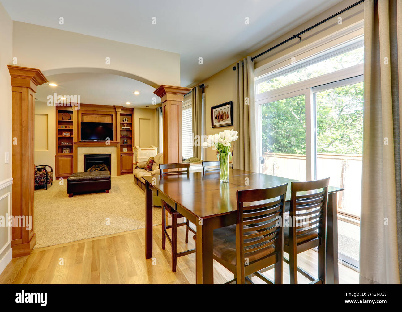 Luxury home interior. View of dining table set with fresh white flowers ...