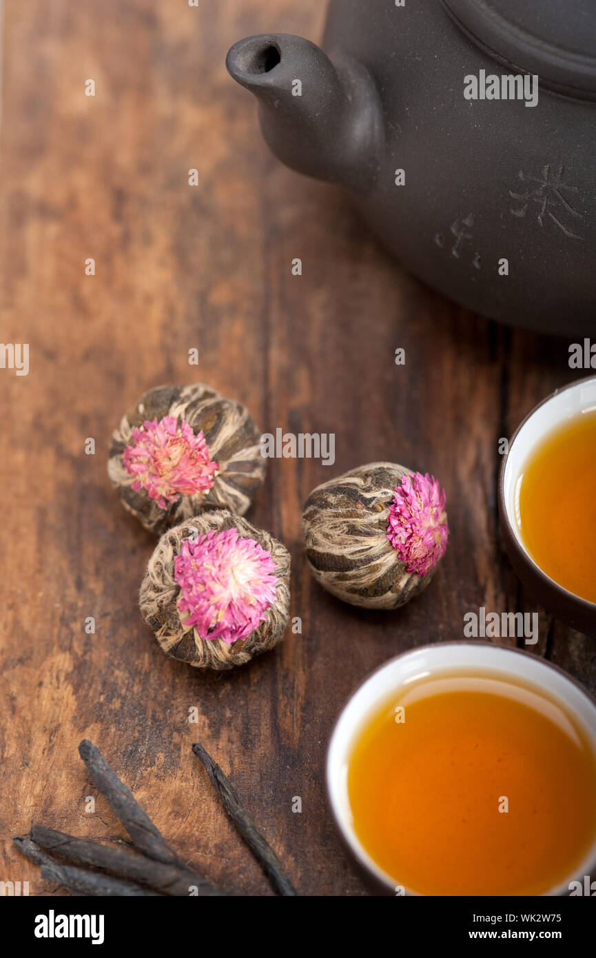 Chinese style herbal floral tea over wood table with raw ingredients ...
