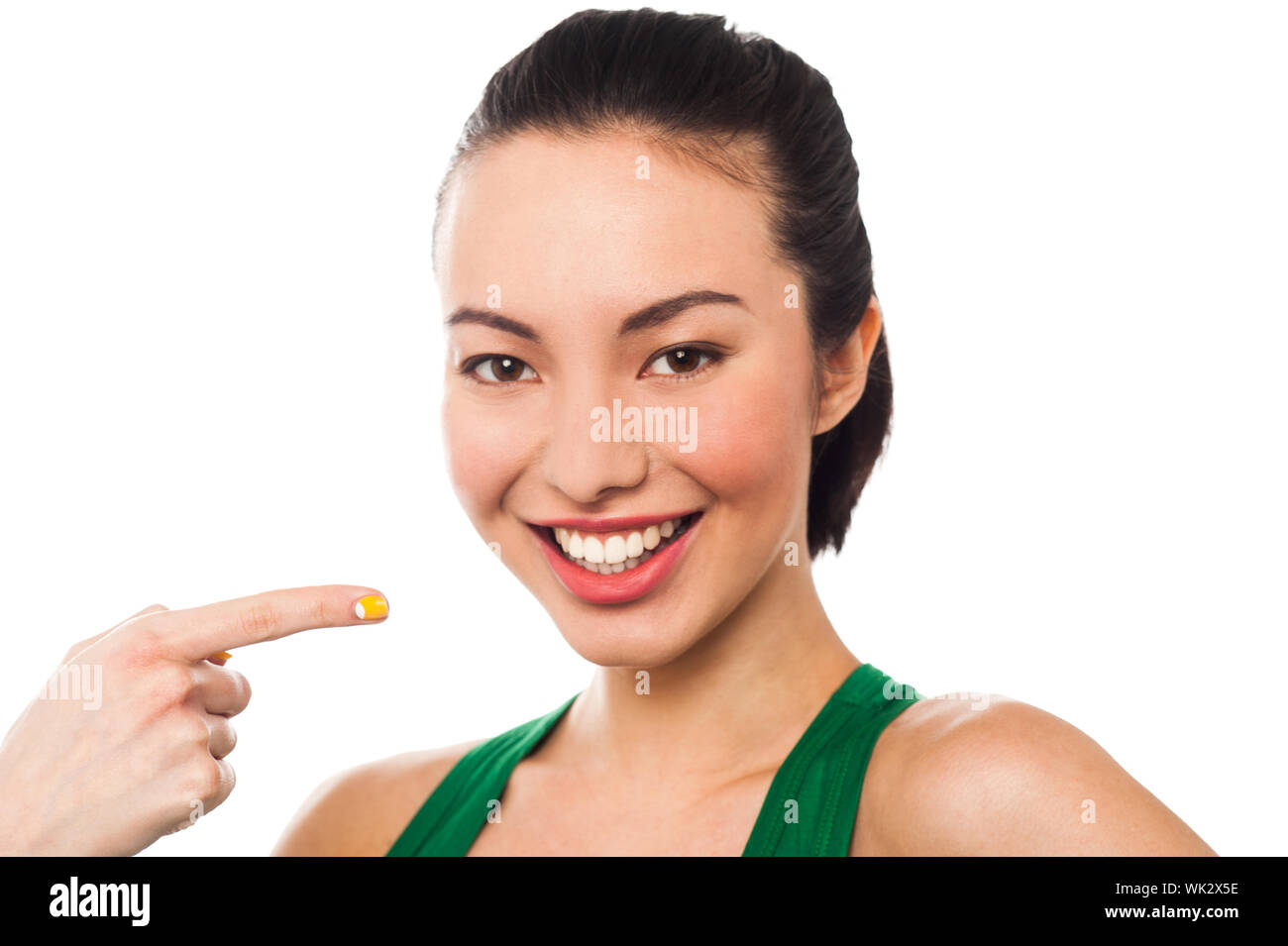Smiling young woman pointing her face Stock Photo - Alamy