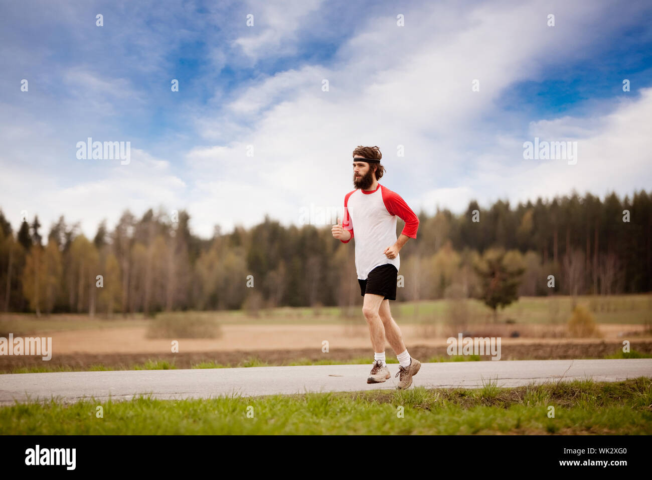 A runner with long hair and beard jogging in the country Stock Photo ...