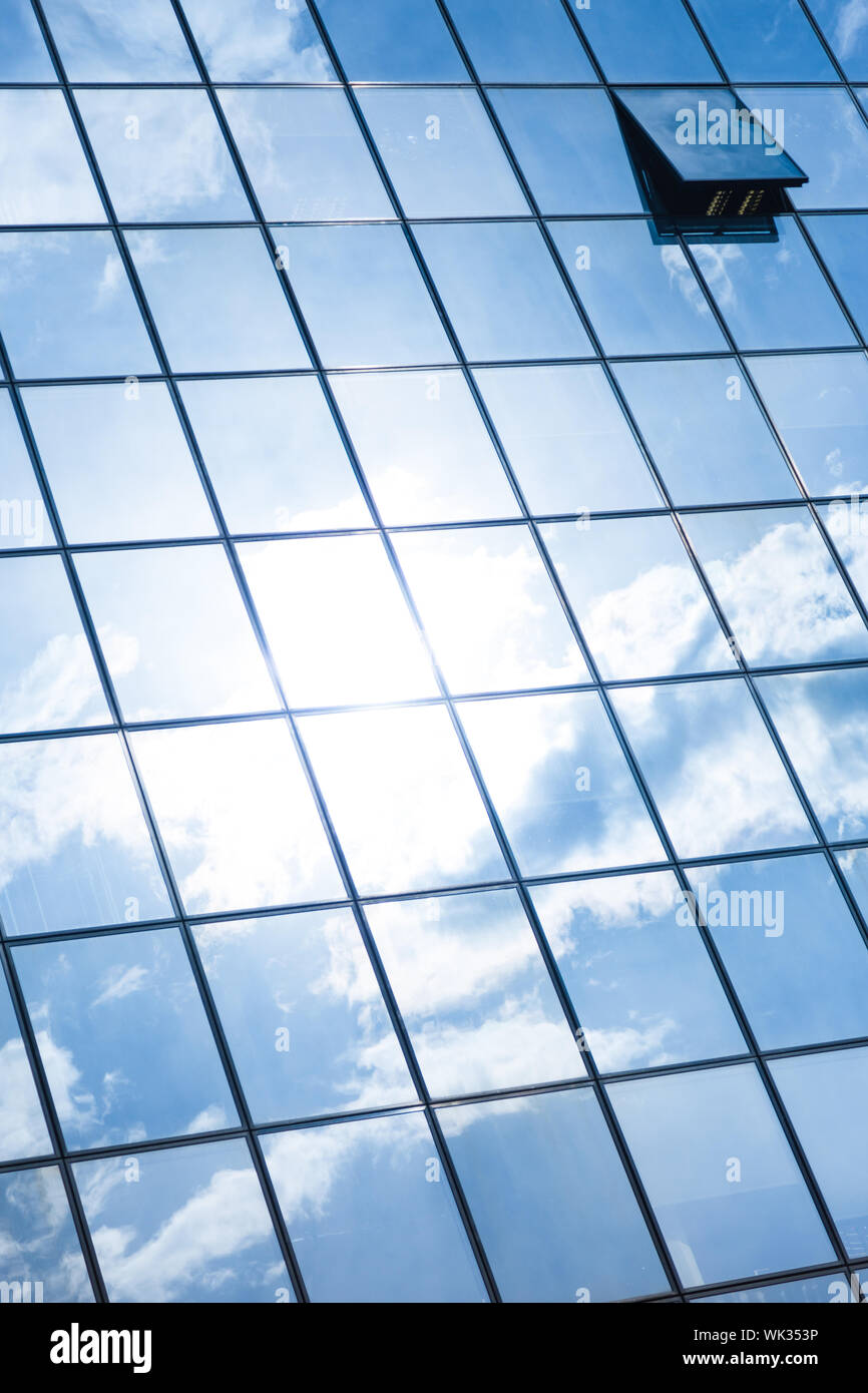 Modern facade of glass and steel with open window reflecting sky and ...