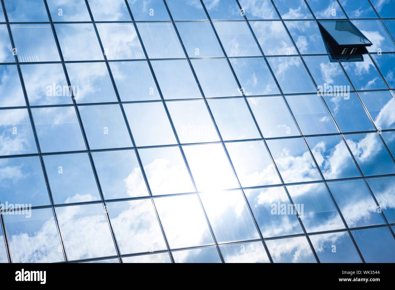 Modern facade of glass and steel with open window reflecting sky and ...