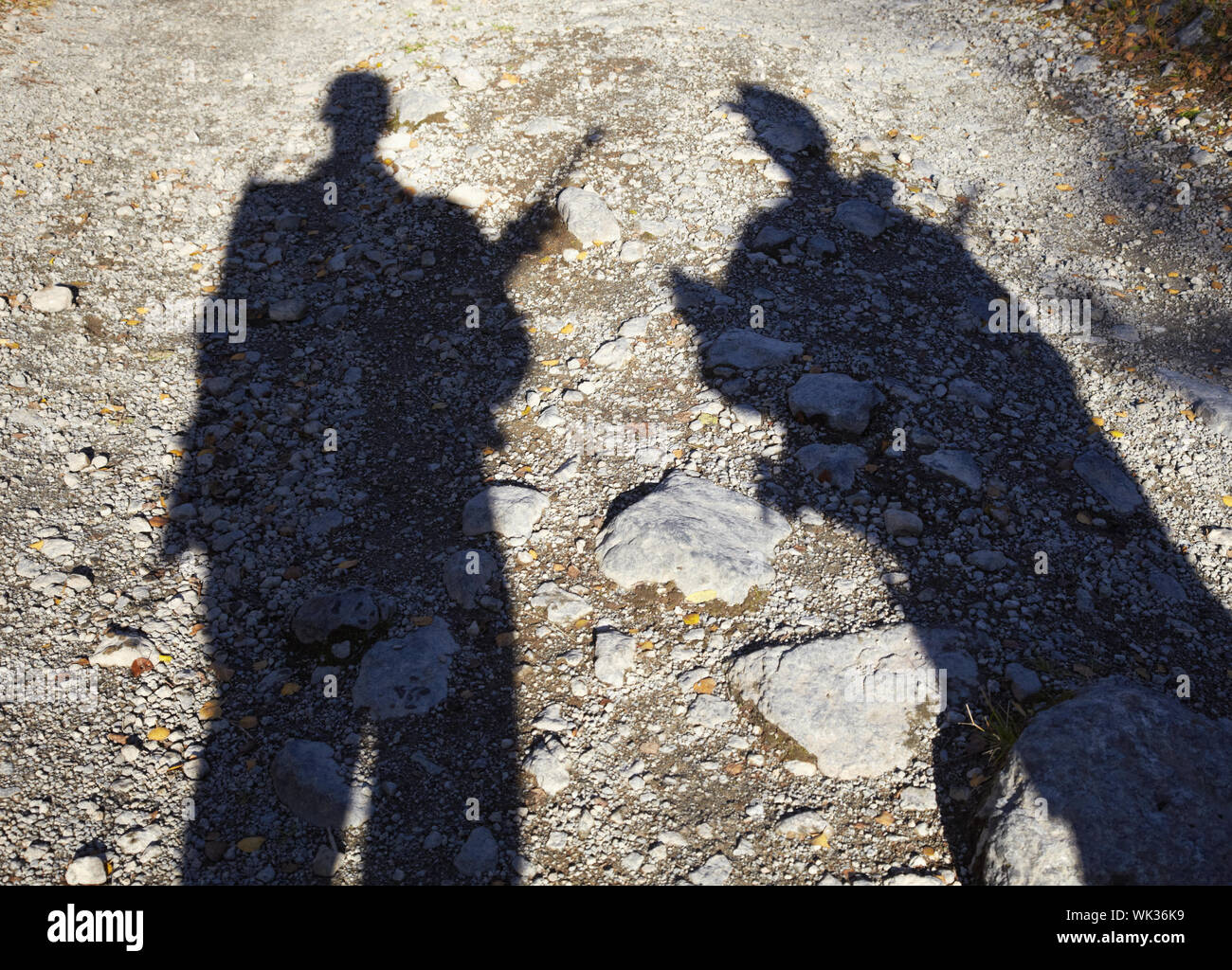 On the ground the shadow of two armed men Stock Photo - Alamy