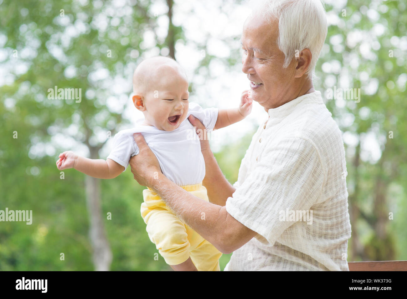 Happy Asian Chinese grandpa and grandson having fun at outdoor garden ...