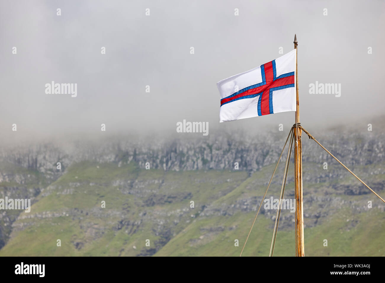 Faroe islands flag and symbol waving on fjord landscape. Denmark Stock ...