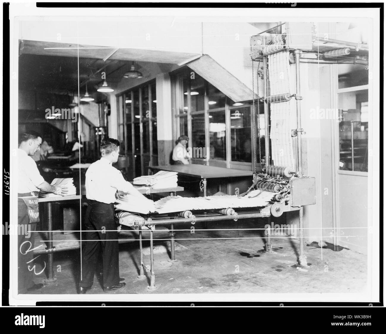 Interior view of newspaper delivery room showing man taking stack of ...