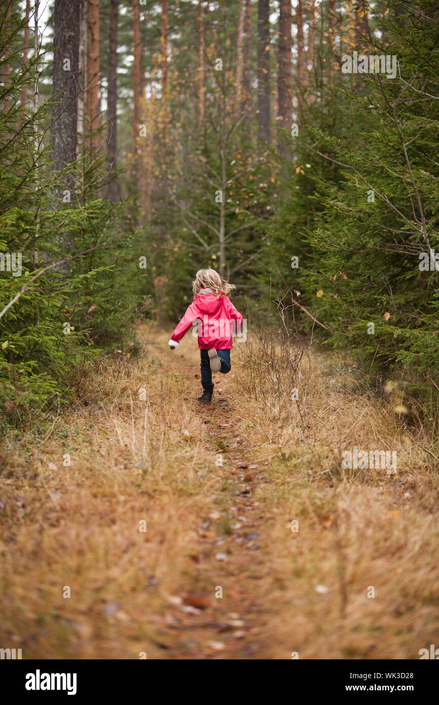 Little girl running in the forest Stock Photo - Alamy