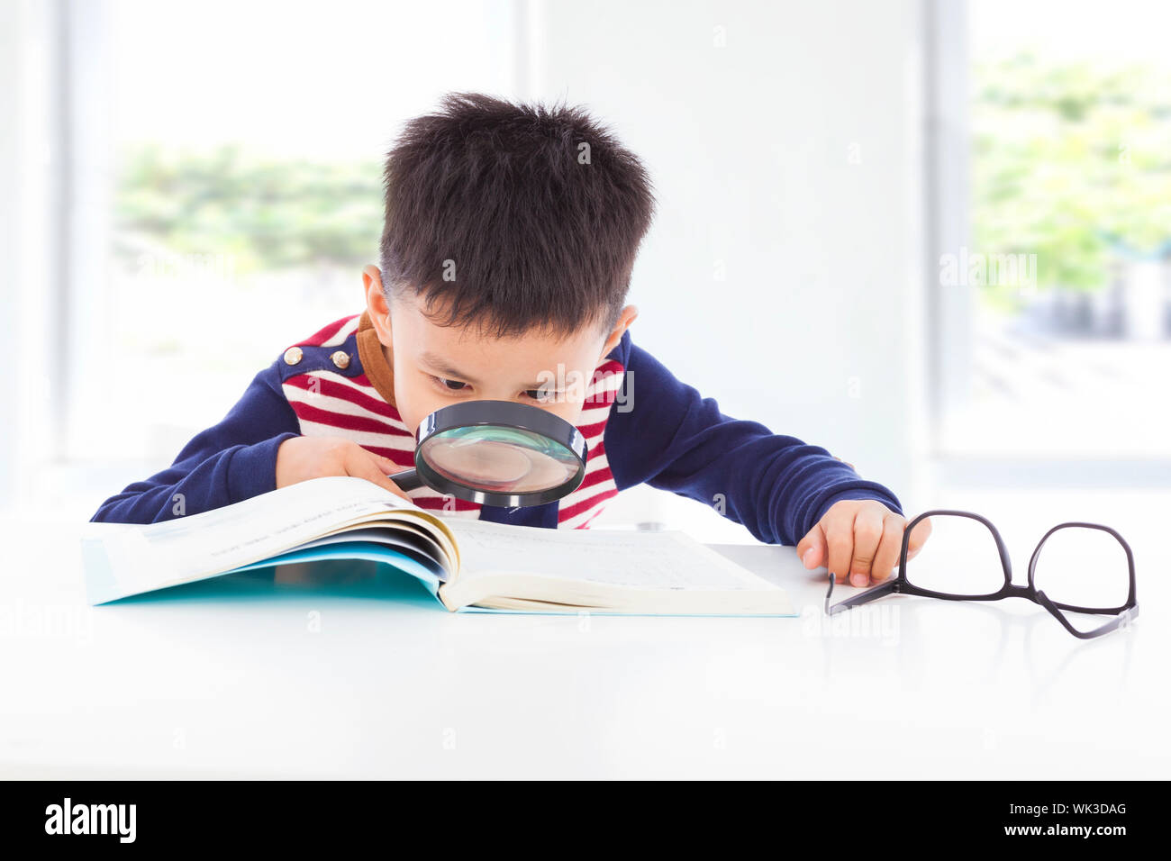 little boy detective searching clues from books Stock Photo - Alamy