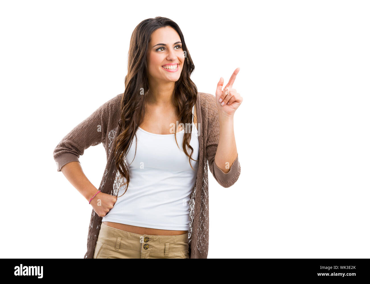 Beautiful brunette woman laughing and pointing to the left, isolated ...