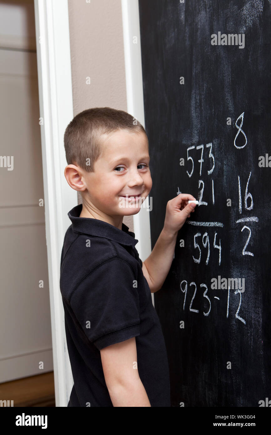 Young Boy in front of the blackboard at school Stock Photo - Alamy