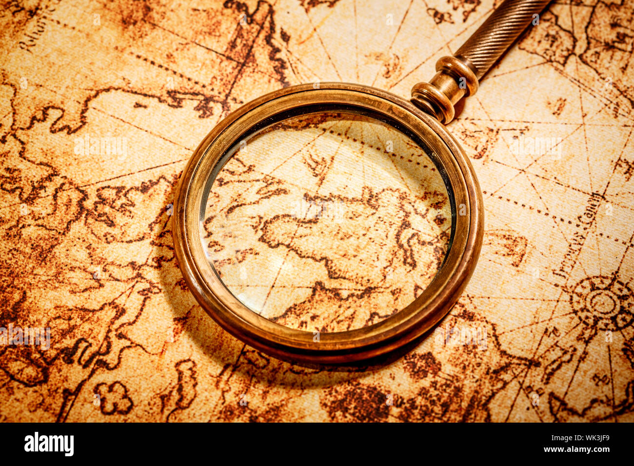 Vintage still life. Vintage magnifying glass lies on an ancient world ...