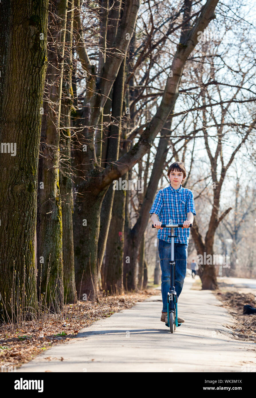 Kid riding his push scooter outdoors Stock Photo - Alamy