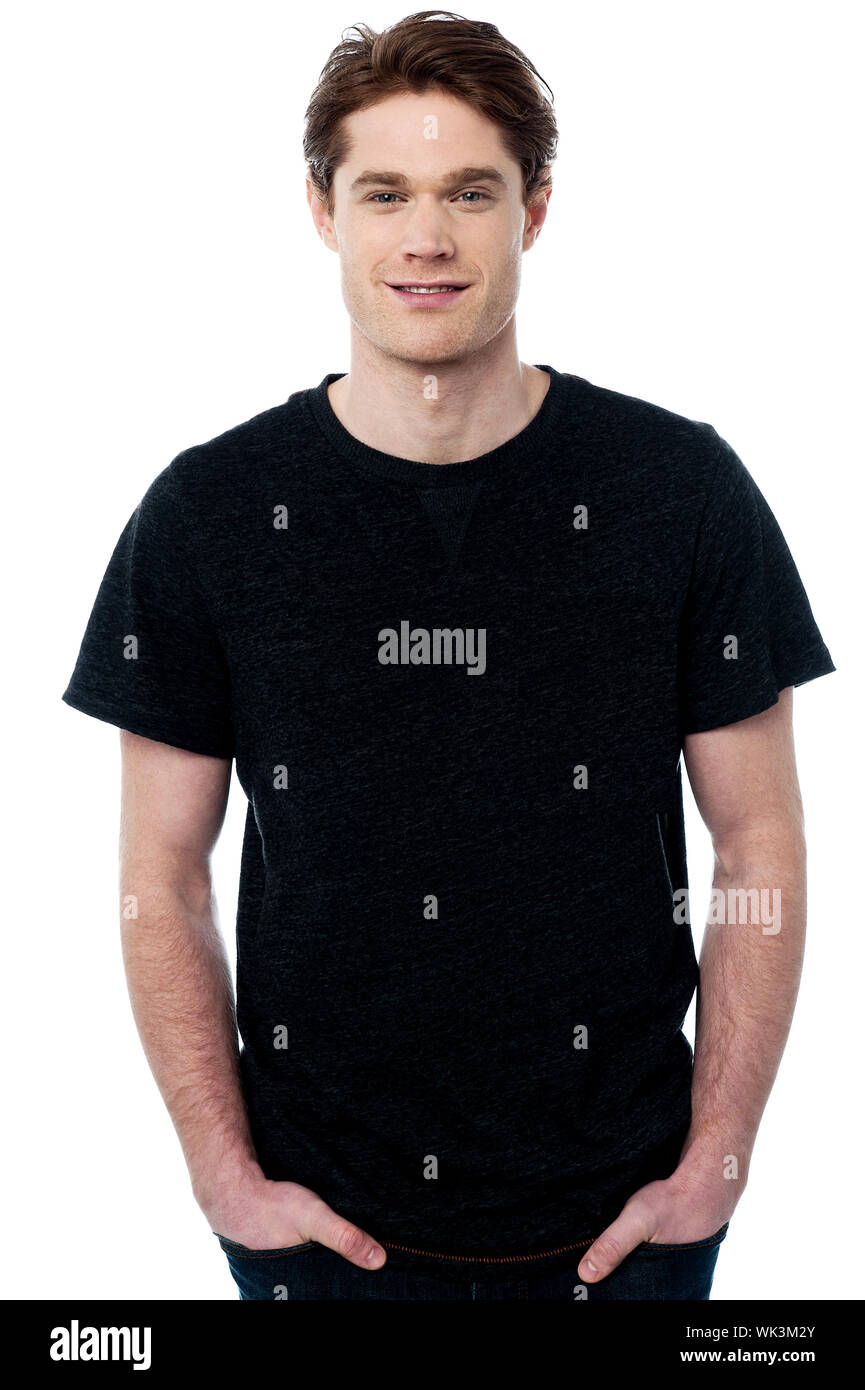 Casual young man standing with hands in pockets Stock Photo - Alamy