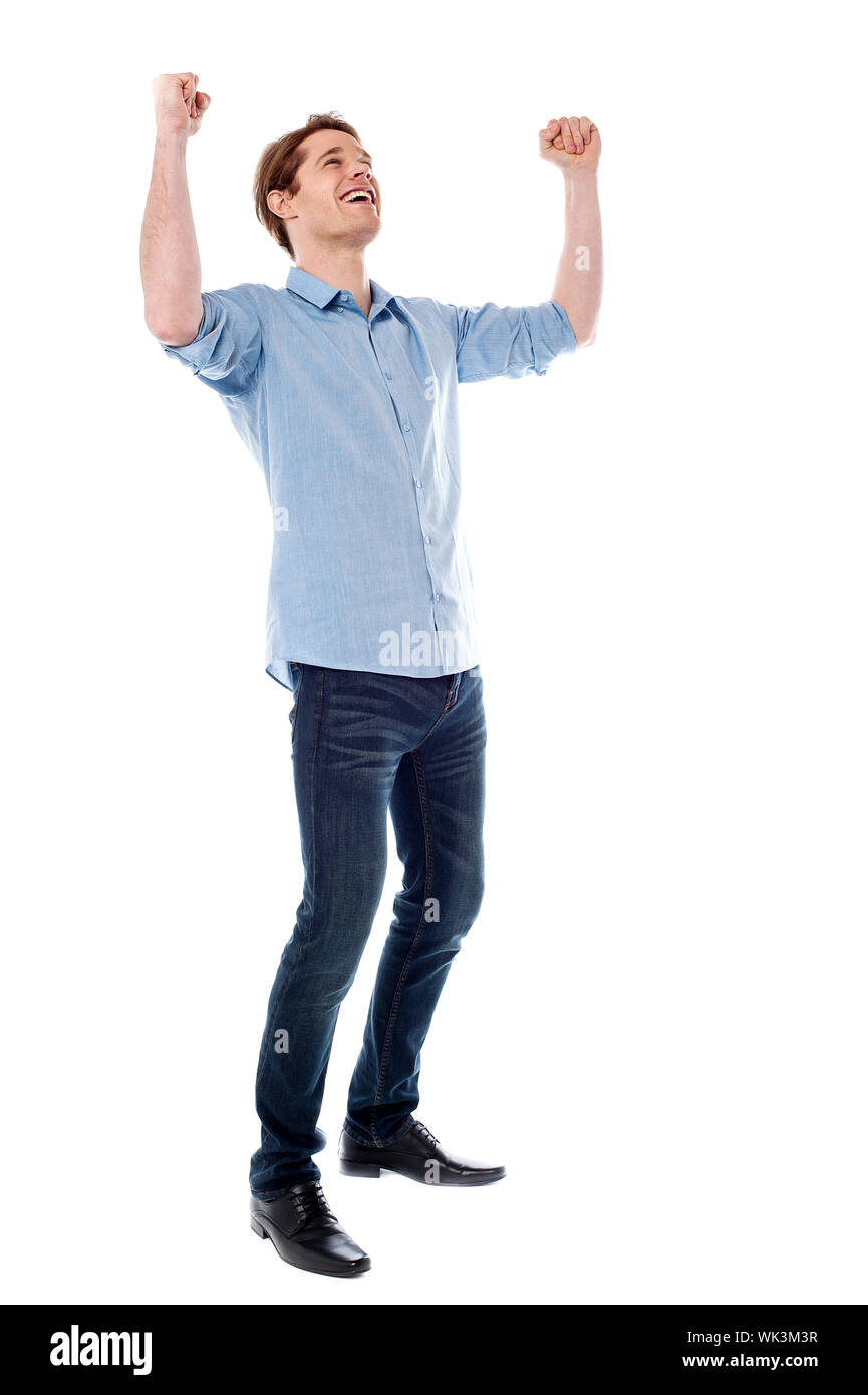 Handsome young man raising his arms in excitement Stock Photo - Alamy
