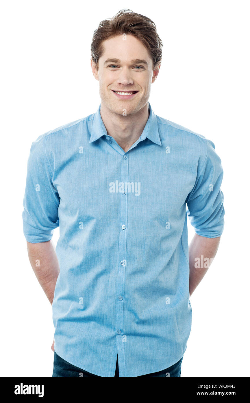 Standing man smiling with hands behind his back Stock Photo - Alamy