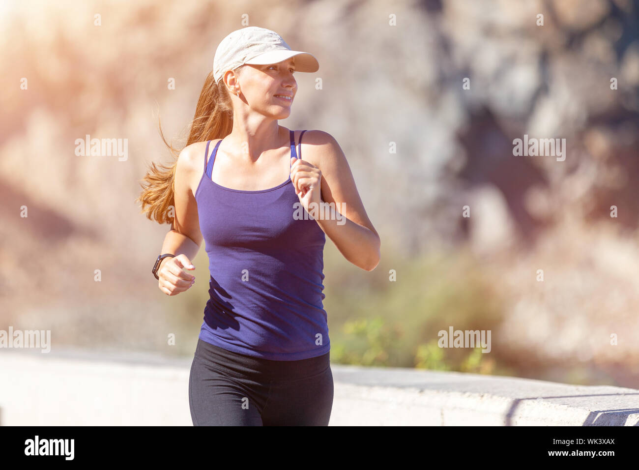 Slim woman in blue top running in the morning. Fitness girl jogging for ...