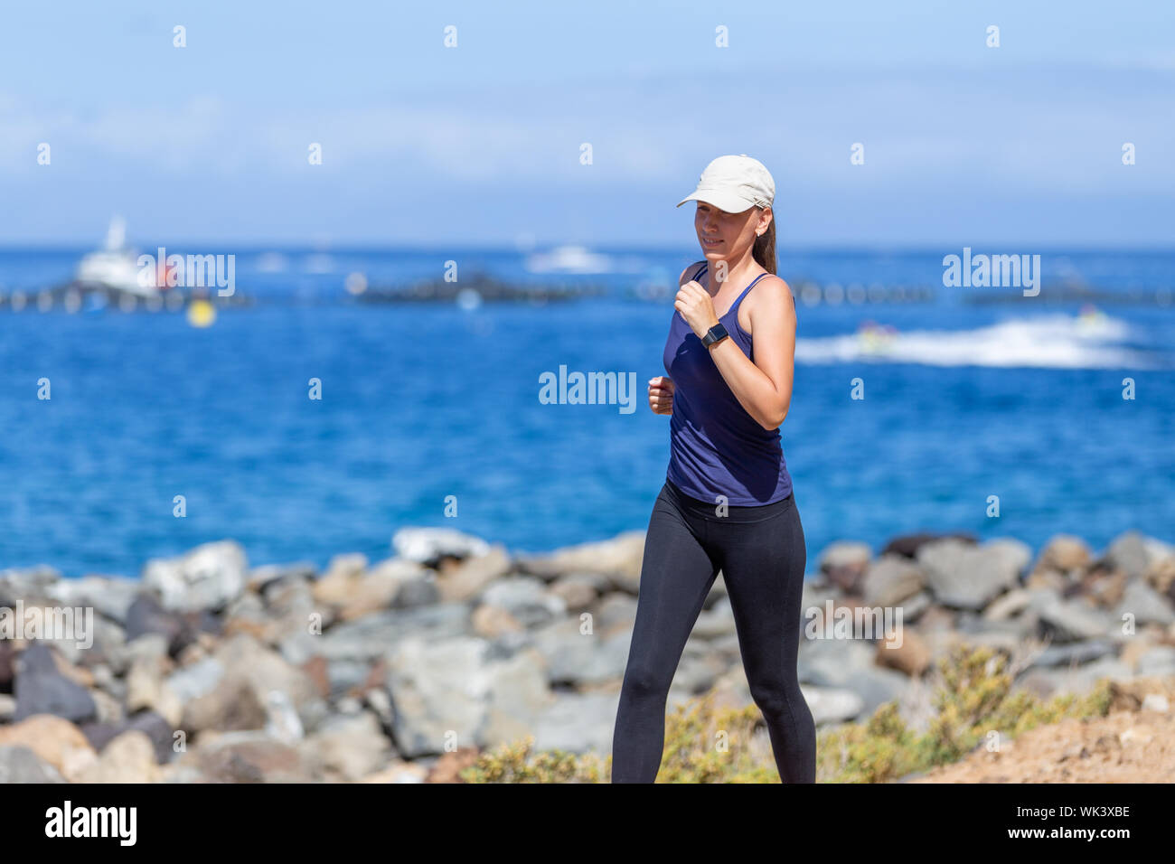 Young slim female runner near the sea jogging in the morning. Healthy ...